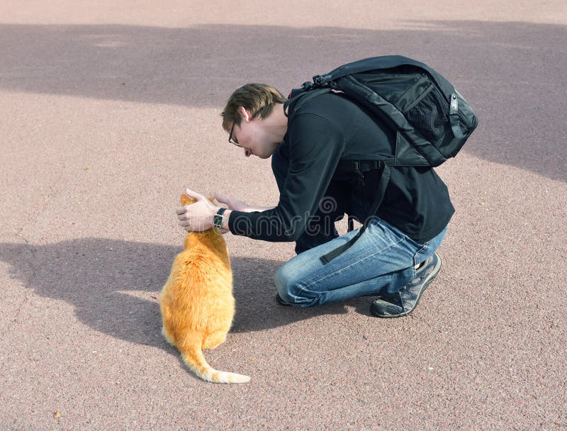 Young man with red cat stock image. Image of stroking - 44419509