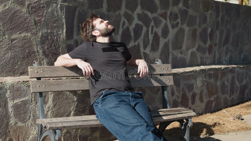 Young Man Relaxes on the Bench As the Wind Blows Stock Video - Video of ...