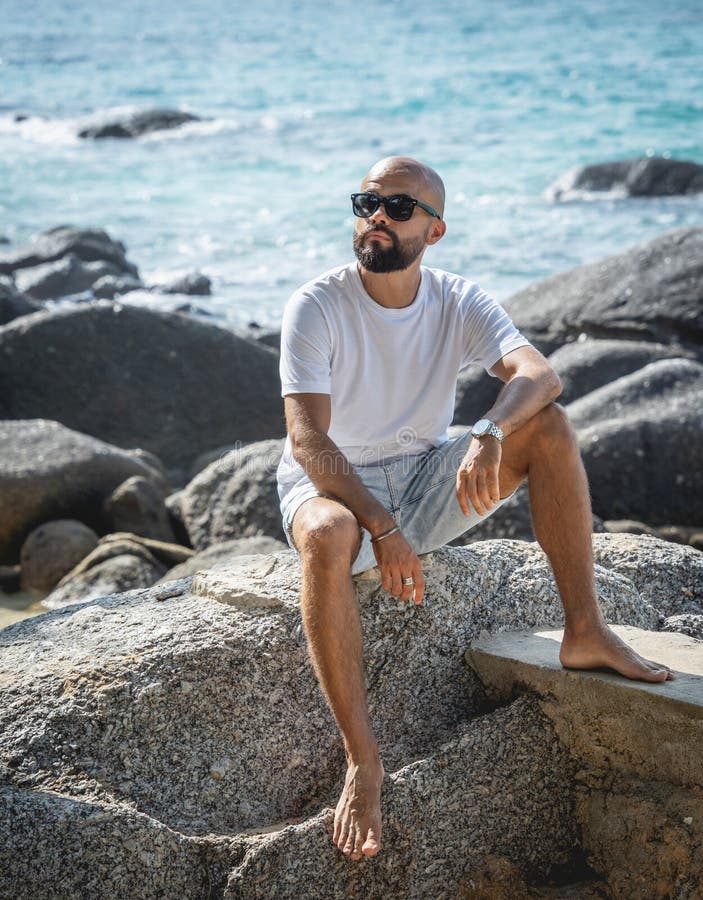Young Man Relaxing on the Beach while Sitting on an Stones Stock Photo ...