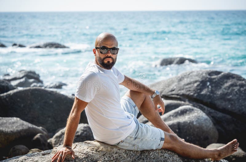 Young Man Relaxing on the Beach while Sitting on an Stones Stock Image ...