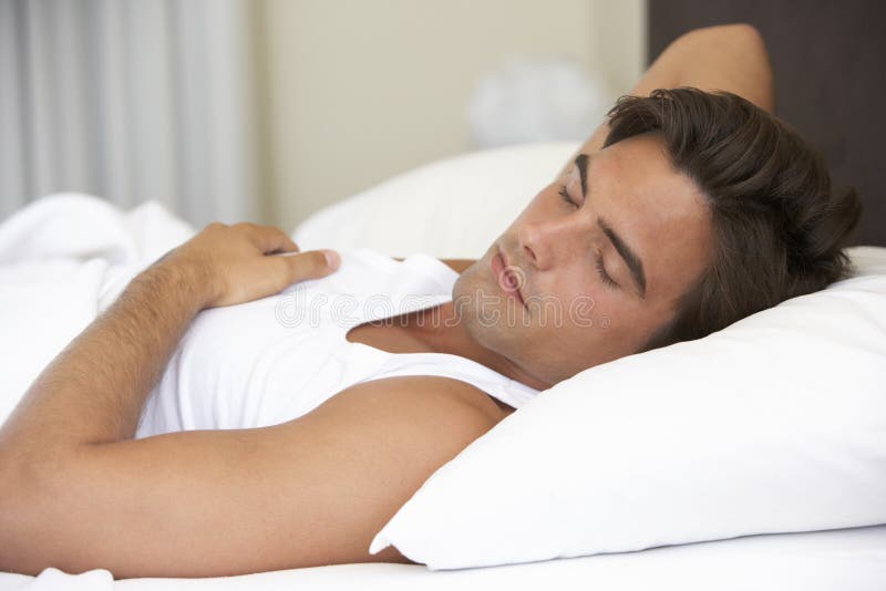 Young Man Relaxing on Bed stock image. Image of resting - 55891811