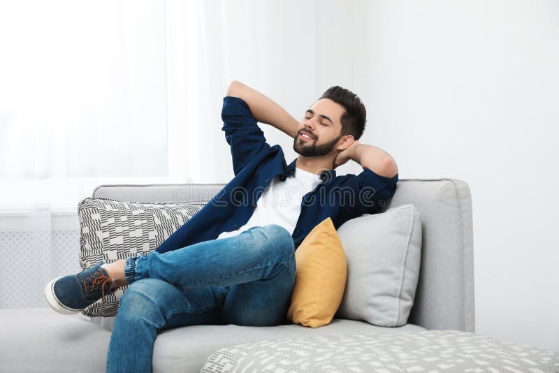 Young Man Relaxing on Couch Stock Image - Image of adult, enjoy: 173065411