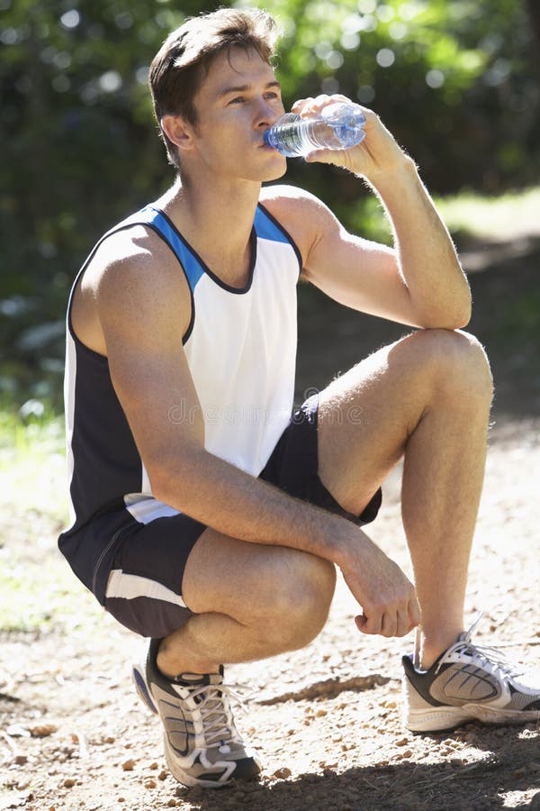 Young Man Relaxing after Exercise and Drinking Water Stock Image ...