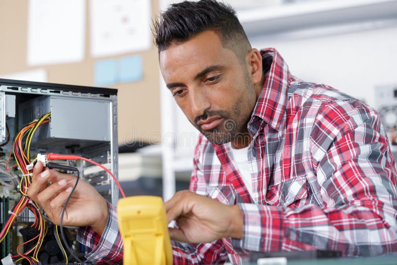 Young Man Repairing Computer while Sitting at Working Place Stock Photo ...