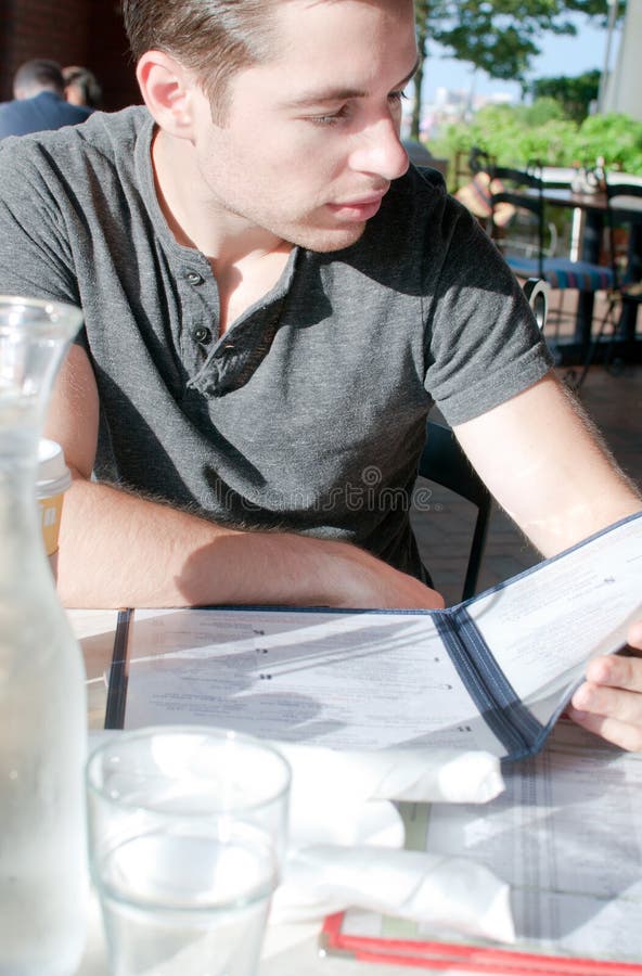 Young Man in Restaurant Reading Menu Stock Photo - Image of bistro ...
