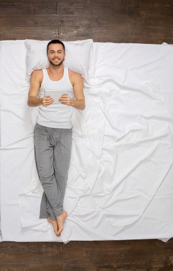 Young Man Relaxation on the Bed Top View Using Digital Tablet Stock ...