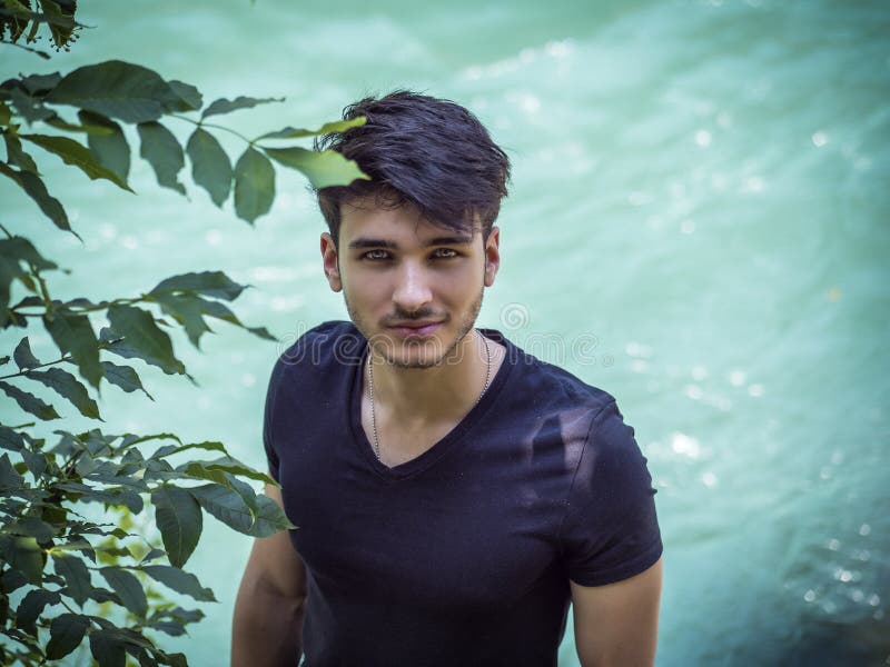 Young Man by River Looking Up at Camera Stock Image - Image of river ...