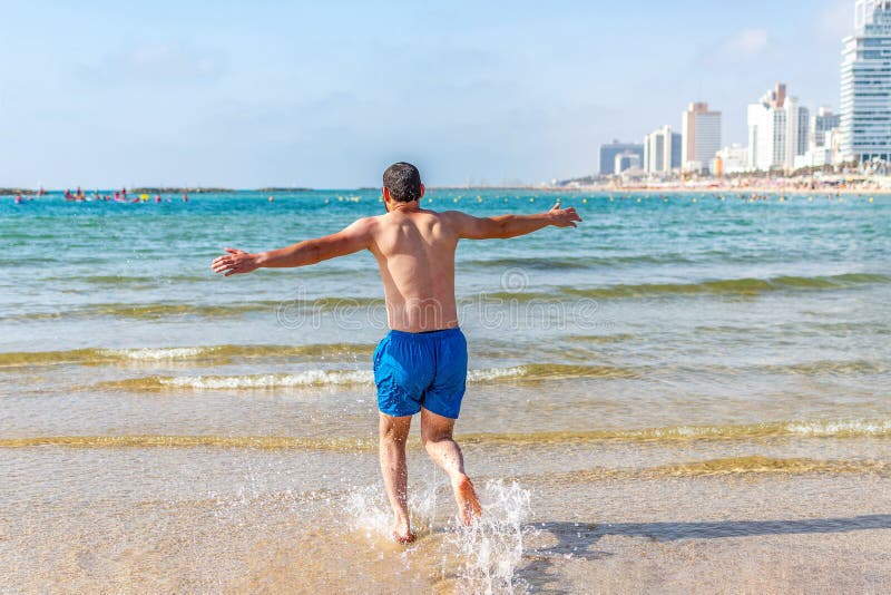 Young Man Running with Arms Open Towards the Sea Stock Photo - Image of ...