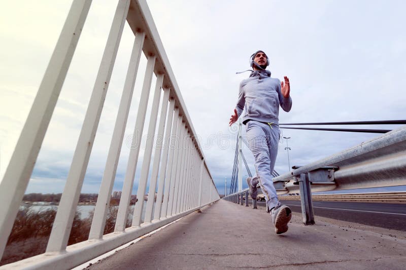 A Young Man Running on the Bridge Along a River. Stock Image - Image of ...