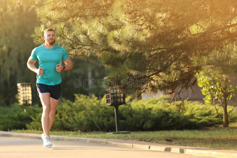 Young man running in park stock photo. Image of running - 124901746