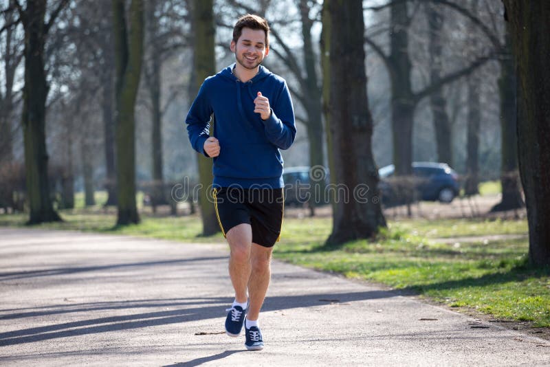 Young Man Runs through the Park Stock Photo - Image of jump, blue: 38812458