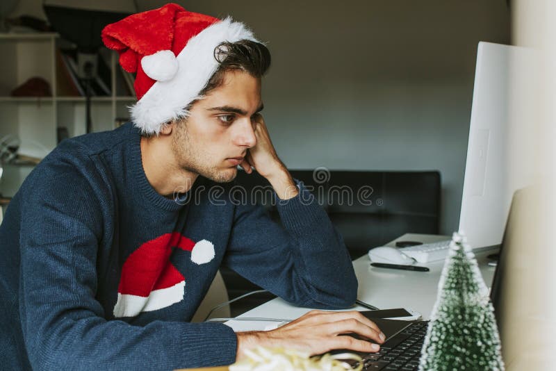 Young Man with Santa Claus Hat and Boring Expression in the Workplace ...