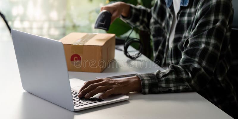 Close-up of a Young Man Using a Laptop while Scanning a Package for ...