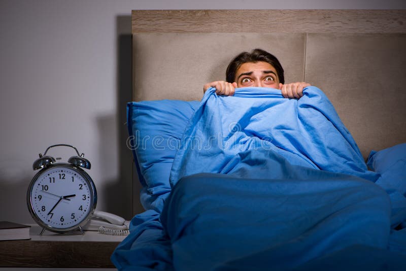 The Young Man Scared in Bed Stock Photo - Image of insomnia, bedroom ...