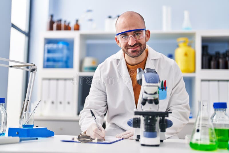 Young Man Scientist Writing on Clipboard at Laboratory Stock Image ...