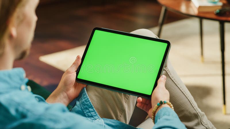 Young Man Scrolling and Tapping on Content on Tablet Computer with ...