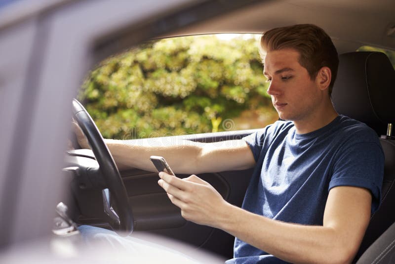 Young Man Sending Text Message Whilst Driving Stock Photo - Image of ...