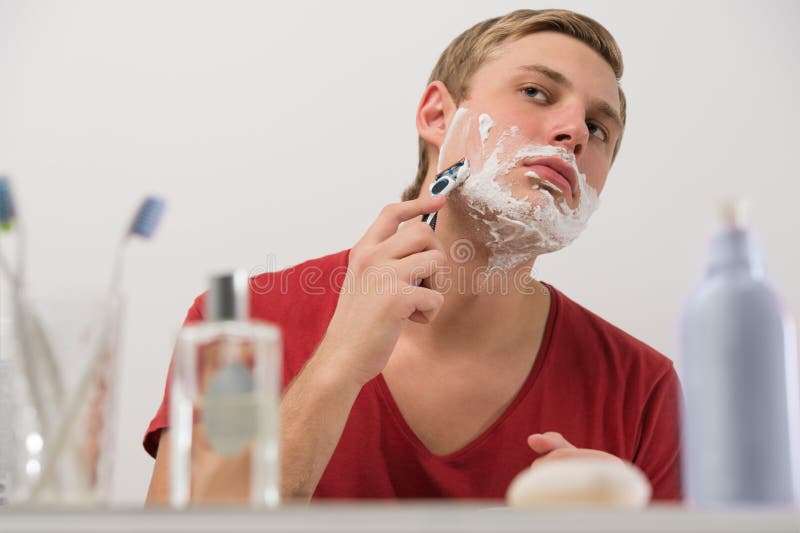 Young man shaving stock image. Image of looking, home - 84905353