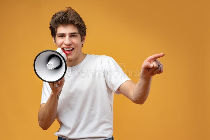 Young Man Shouting into Megaphone Making Announcement Against Yellow ...