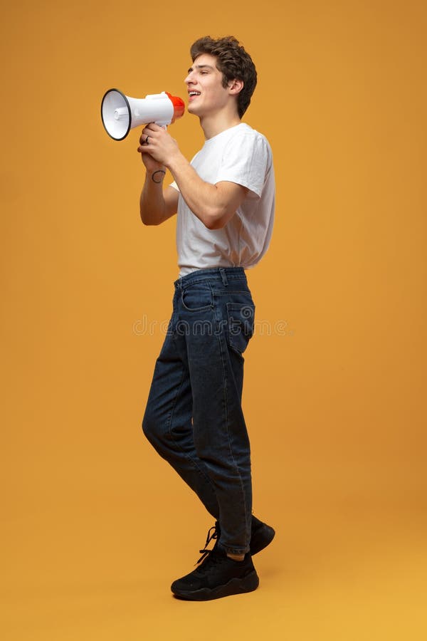 Young Man Shouting into Megaphone Making Announcement Against Yellow ...