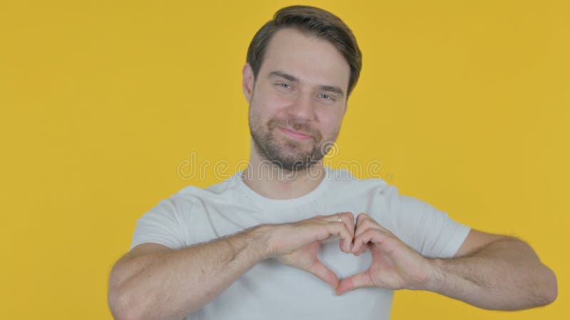 Young Man Showing Heart Shape by Hands on Yellow Background Stock Image ...