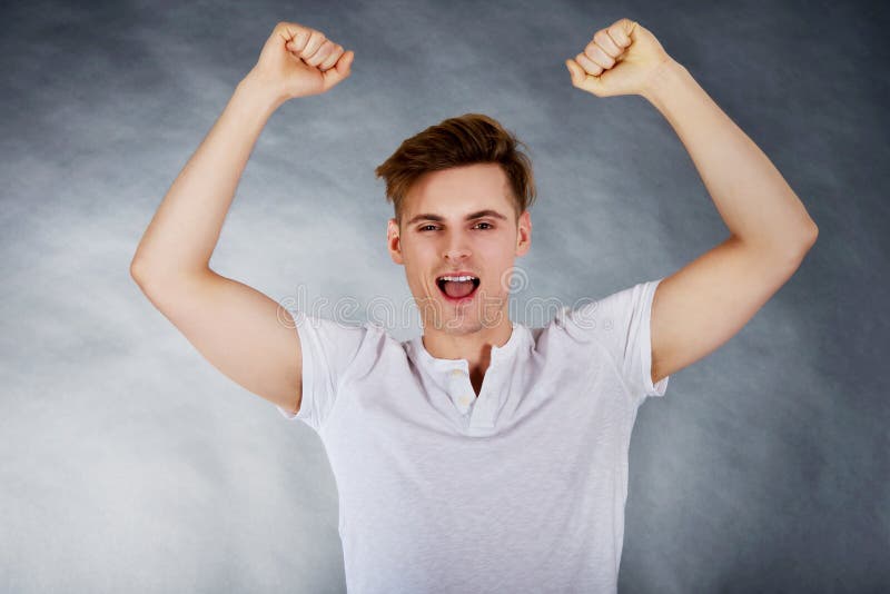Young Man Showing Winner Gesture. Stock Photo - Image of grey, handsome ...