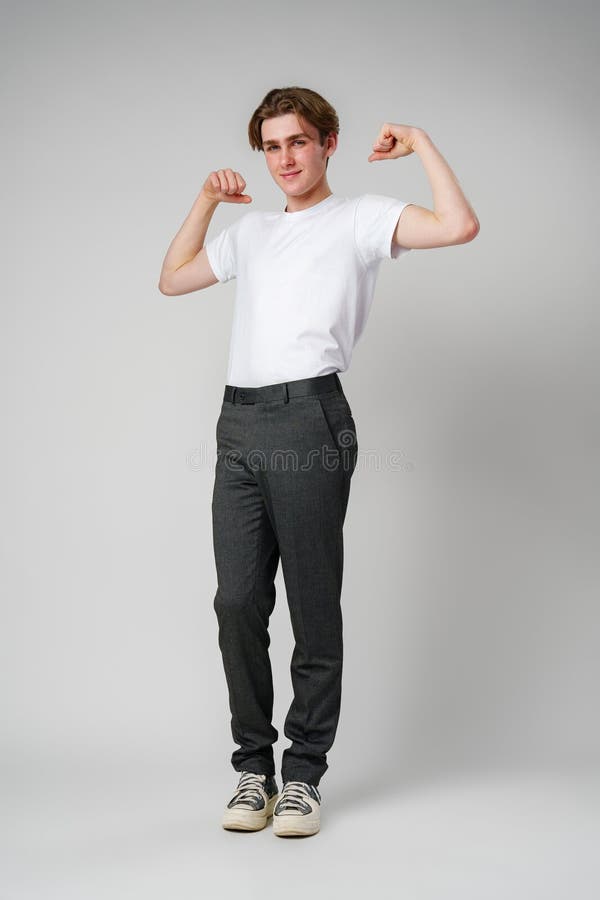 Young Man Flexing Muscles in Front of White Background Stock Photo ...