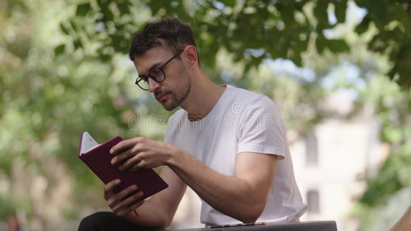 Man Reading Notebook in Park: Education, Work, and Planning Stock Video ...