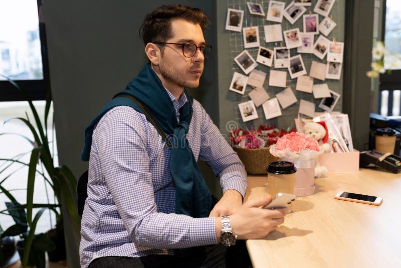 A Young Man Sits at the Counter Waiting for His Order in a Cozy Cafe ...