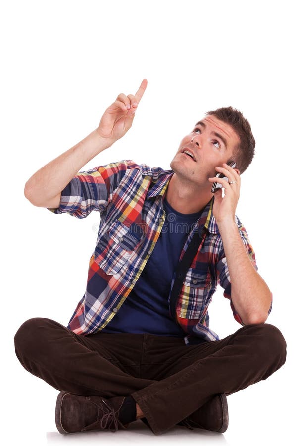 Young Man Sits, Talks, Points and Looks Up Stock Photo - Image of shirt ...