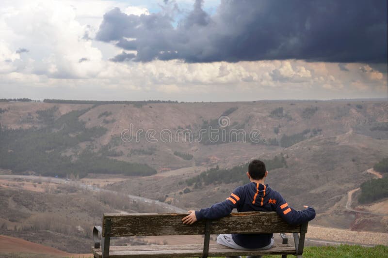 Young Man Sitting Alone on a Bench Overlooking the Mountain and Valley ...
