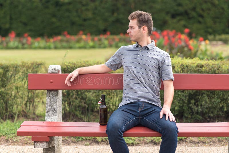 Young Man Sitting on Bench with a Bottle of Beer Stock Image - Image of ...