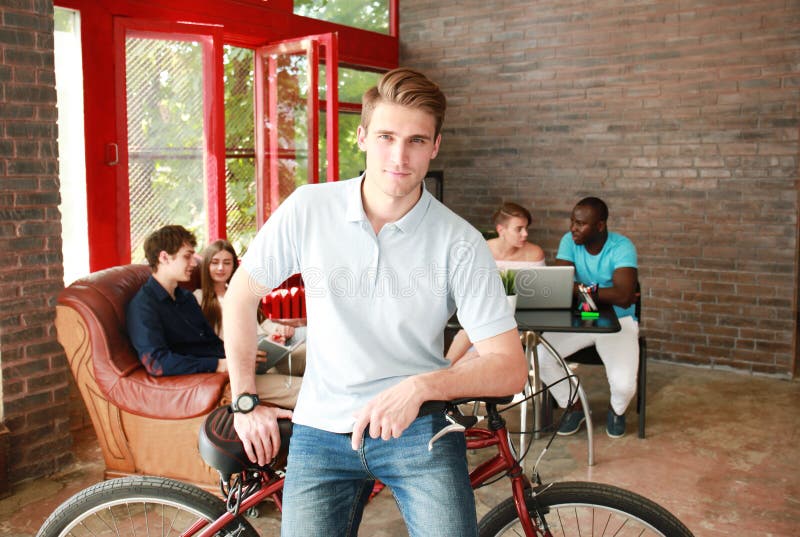 Young Man Sitting on a Bicycle in a Modern Office. Stock Photo - Image ...