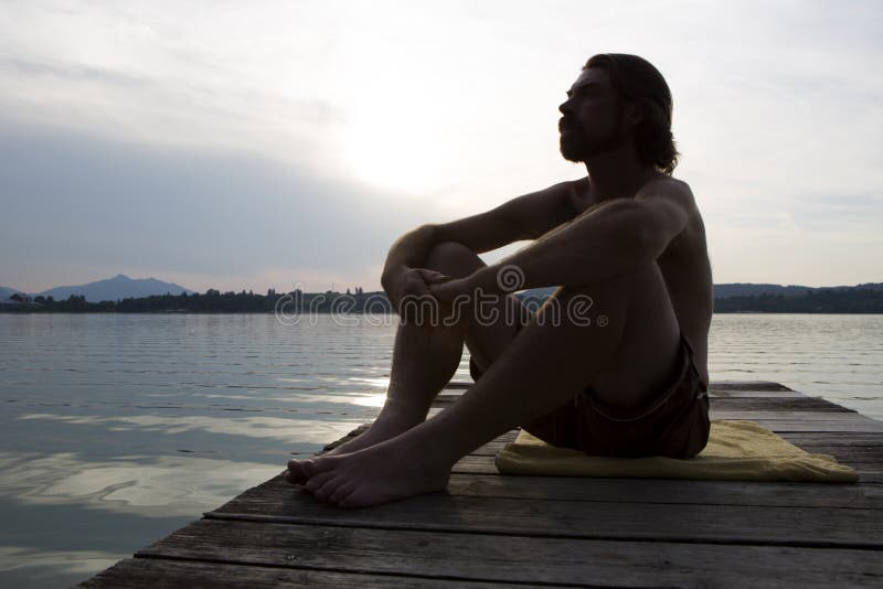 Young Man Sitting at a Bridge in Evening Light Stock Image - Image of ...