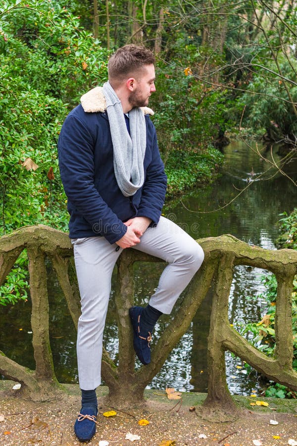 Young Man Sitting on Bridge with Stone Railing Stock Image - Image of ...