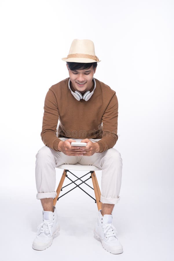 Young Man Sitting on Chair and Using Mobile Phone Stock Photo - Image ...