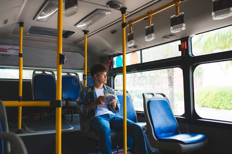 Young Man Sitting in City Bus and Reading a Book. Stock Photo - Image ...