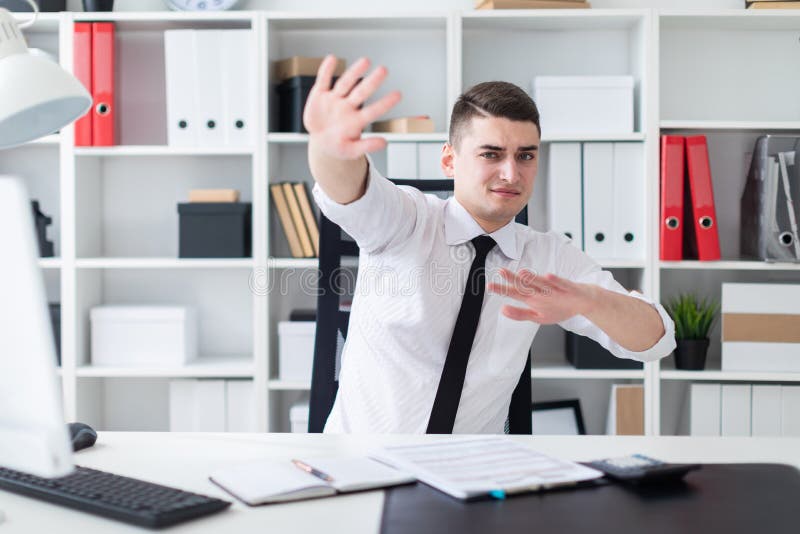 A Young Man Sitting at a Computer Desk in the Office and Spread His ...