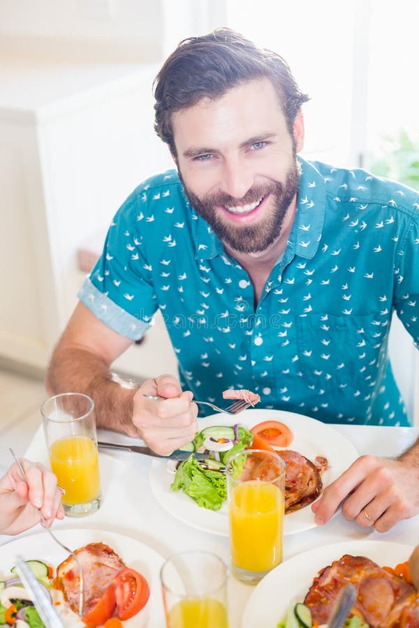 Young Man Sitting at Dining Table Smiling Stock Image - Image of ...