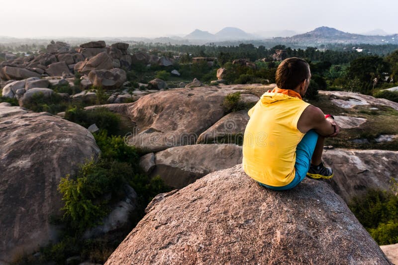Young Man Sitting on the Edge of Mountain and Looking Forward Stock ...