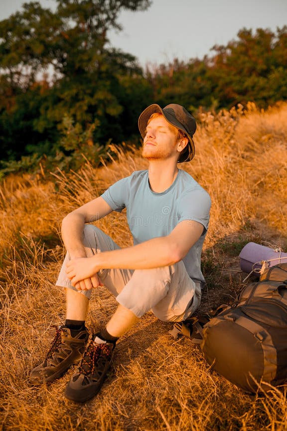 A Young Man Sitting and Enjoying the Sun Rays Stock Image - Image of ...