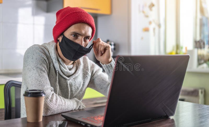 A Young Man is Sitting in Front of a Laptop Screen at Home, Working ...
