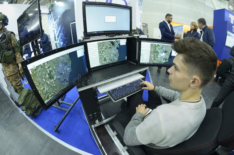 Young Man Sitting in Front of Monitors and Working with Military ...