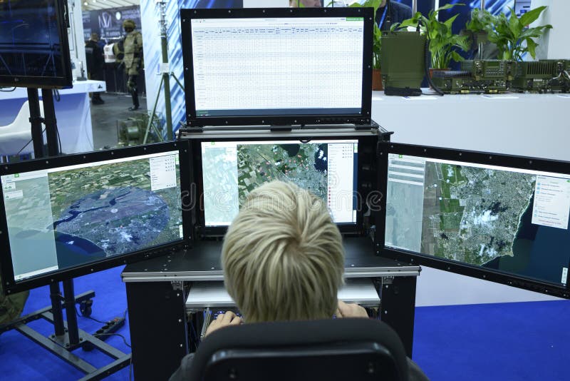 Young Man Sitting in Front of Monitors and Working with Military ...
