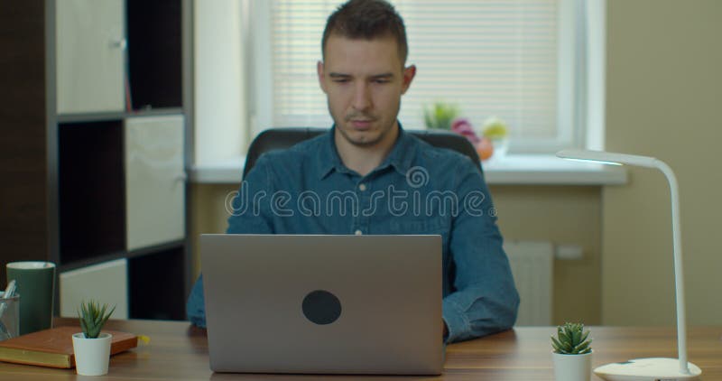 Young Man Sitting at His Desk at Home, Opens and Starts Using Laptop ...