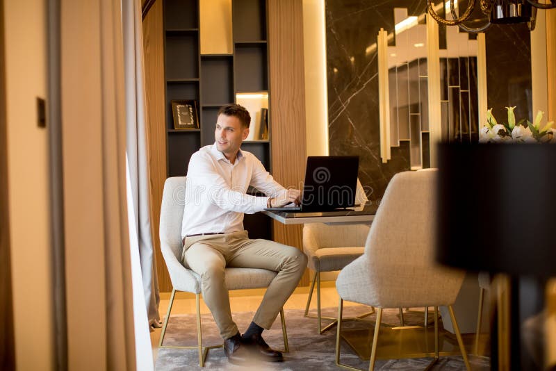 Young Man Sitting in a Luxurious Room in Front of a Laptop Computer ...