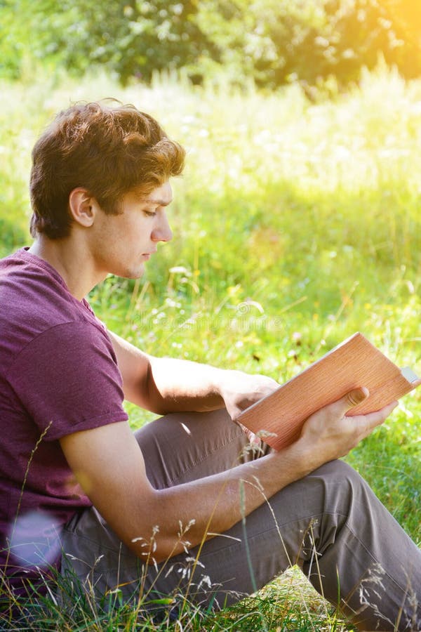 Young Man is Sitting and Reading a Book Stock Image - Image of outdoor ...