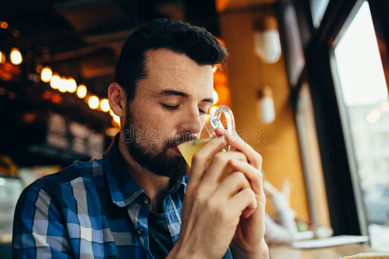 Young Man is Sitting in the Restaurant and Tasting a Warm Drink. Stock ...