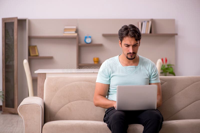 Young Man Sitting on the Sofa with Computer at Home Stock Image - Image ...
