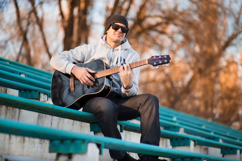 Young Man Sitting on Steps Playing Guitar and Singing, Music Concept ...